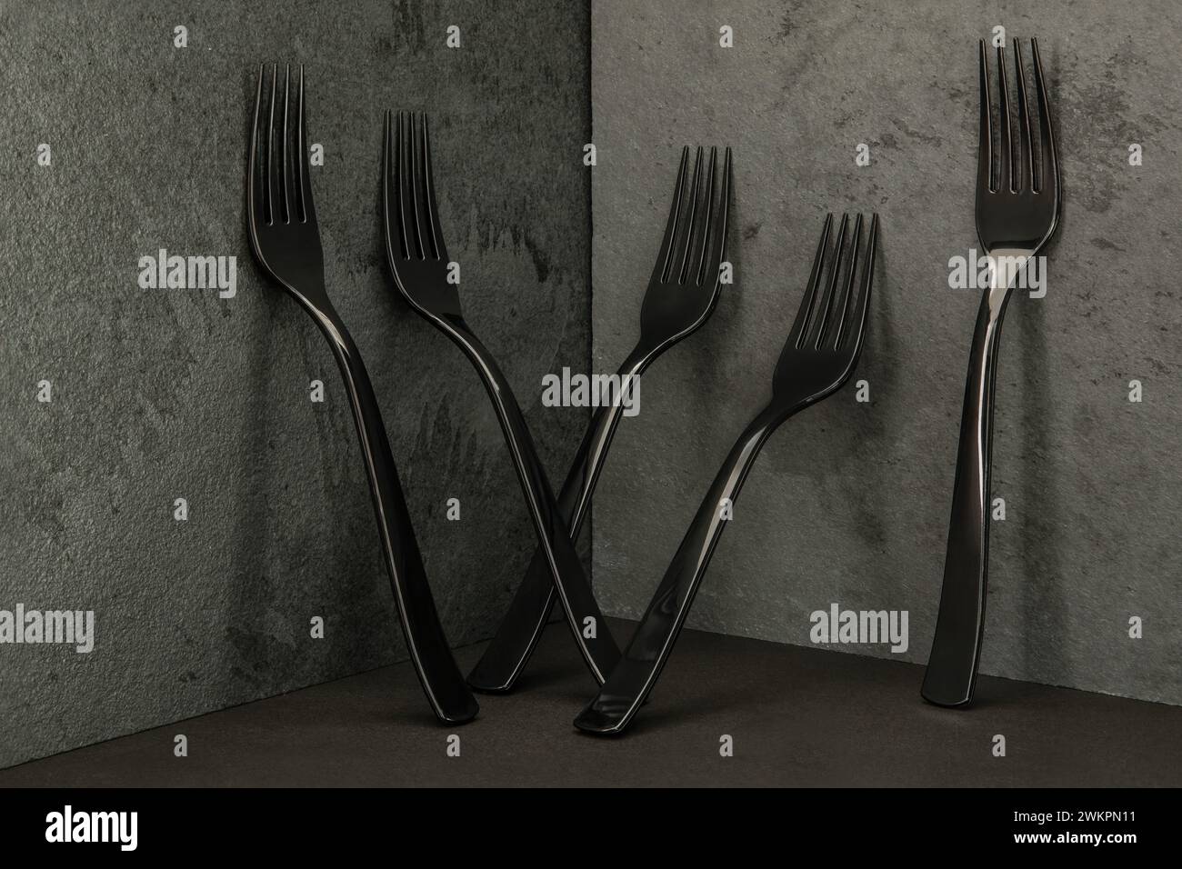 Five black plastic forks on an elegant black slate background Stock ...