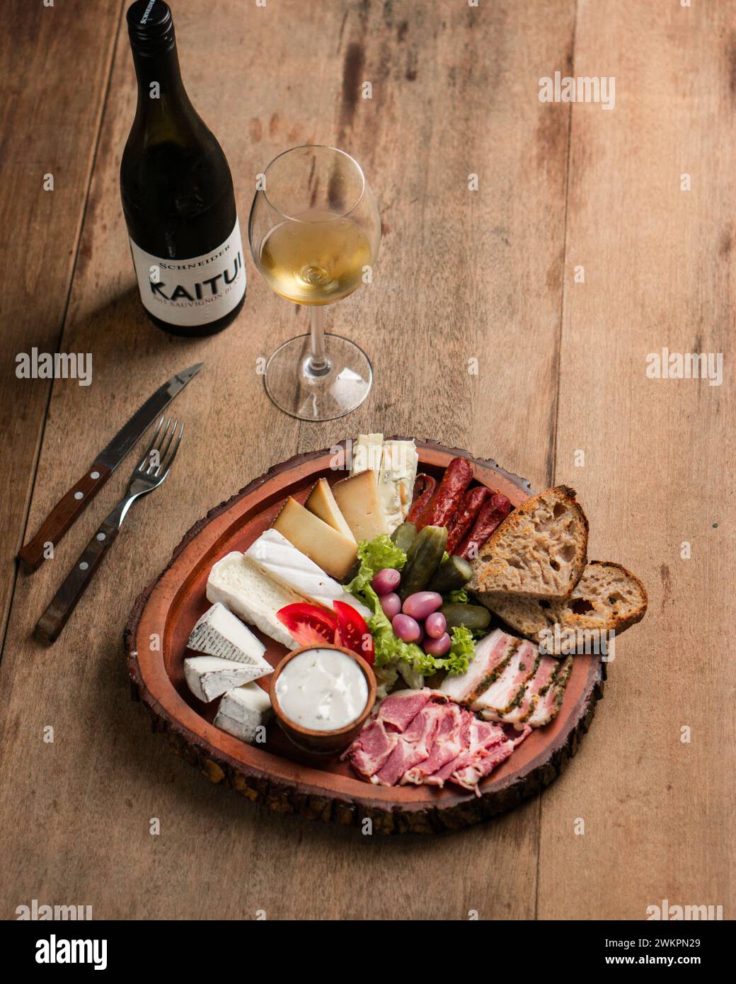 high angle a wooden plate overflowing with a variety of meats, cheeses ...