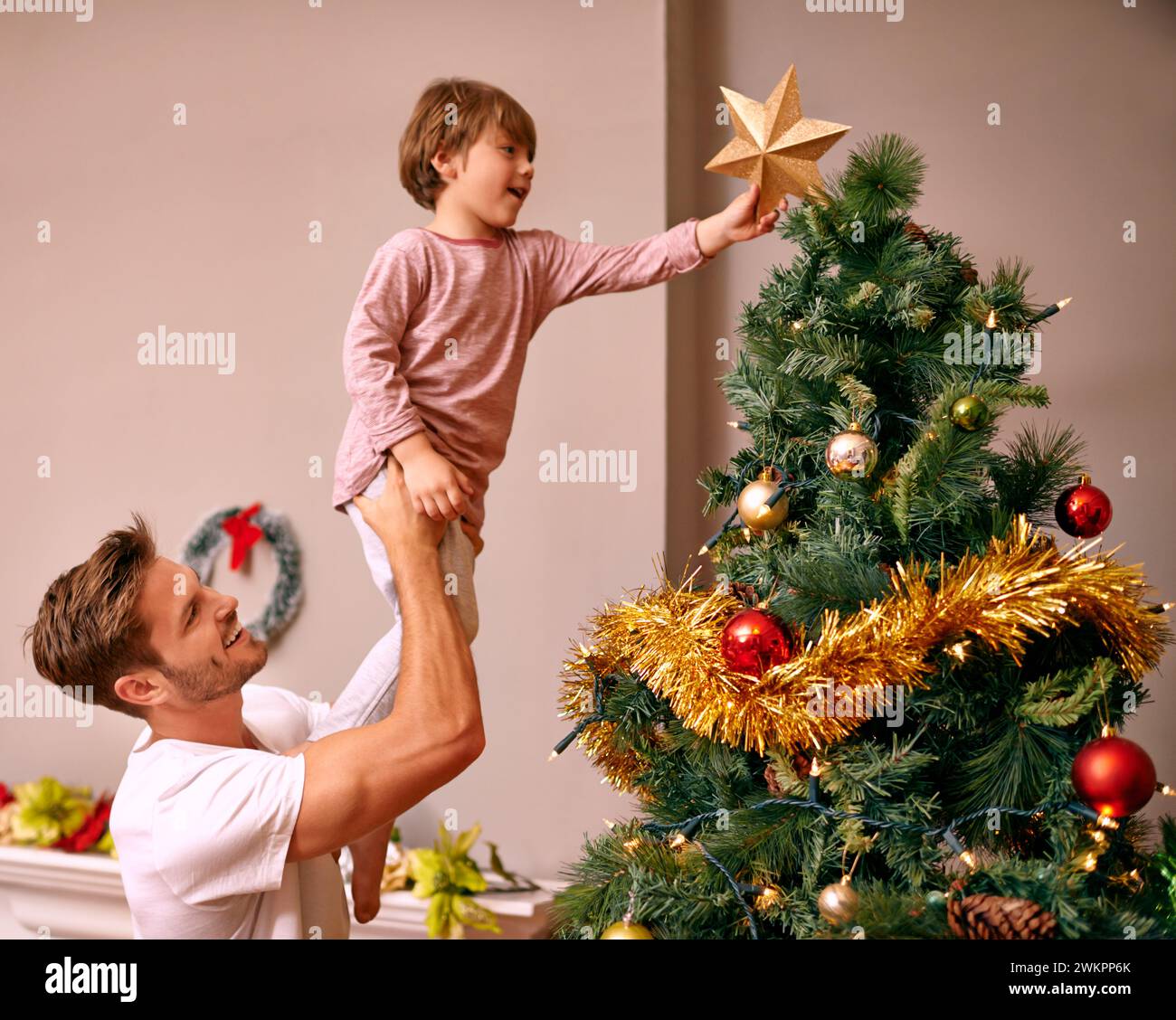Father, son and happy with bonding by christmas tree for celebration ...