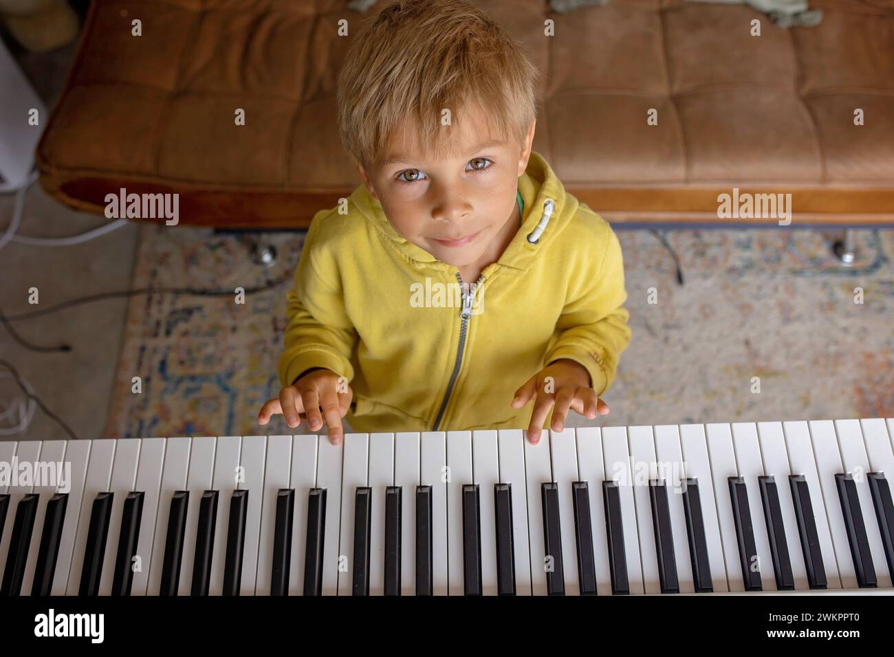 Child, blond boy, playing piano at home, learning Stock Photo - Alamy