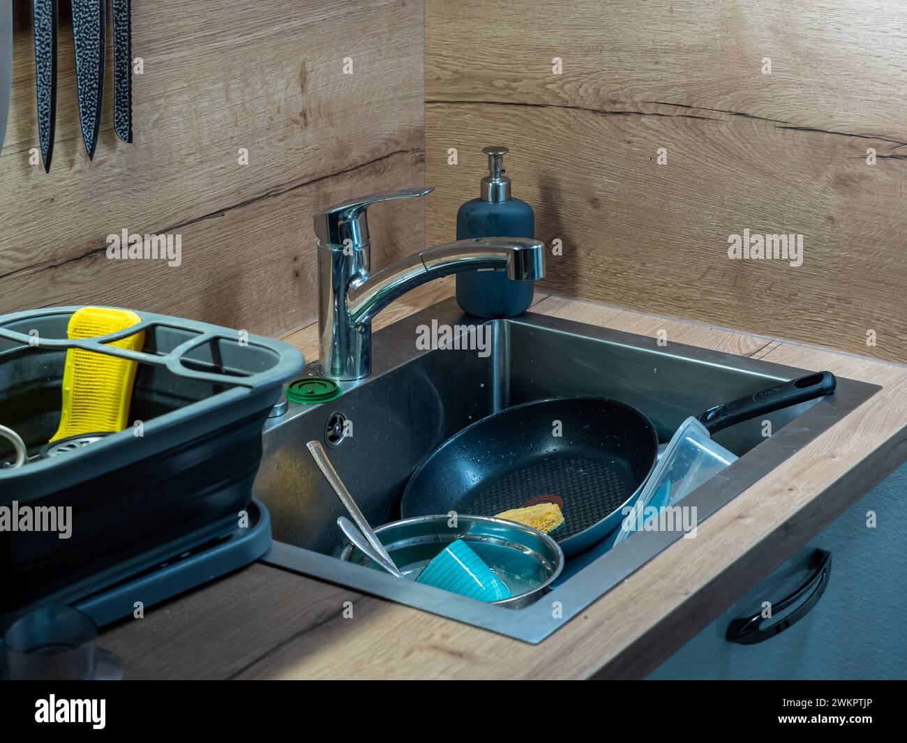 washing dishes, a sink full of things to wash. Wooden background ...