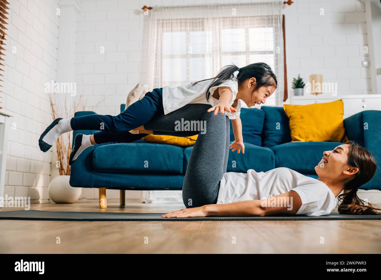 A harmonious family practices the little bird posture in yoga at home ...