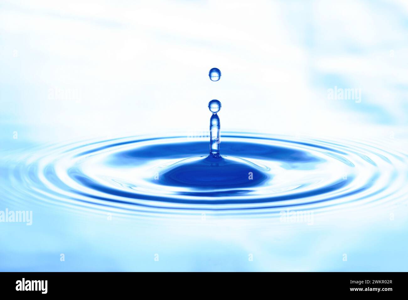 a drop of water jumps upwards from the water surface Stock Photo - Alamy