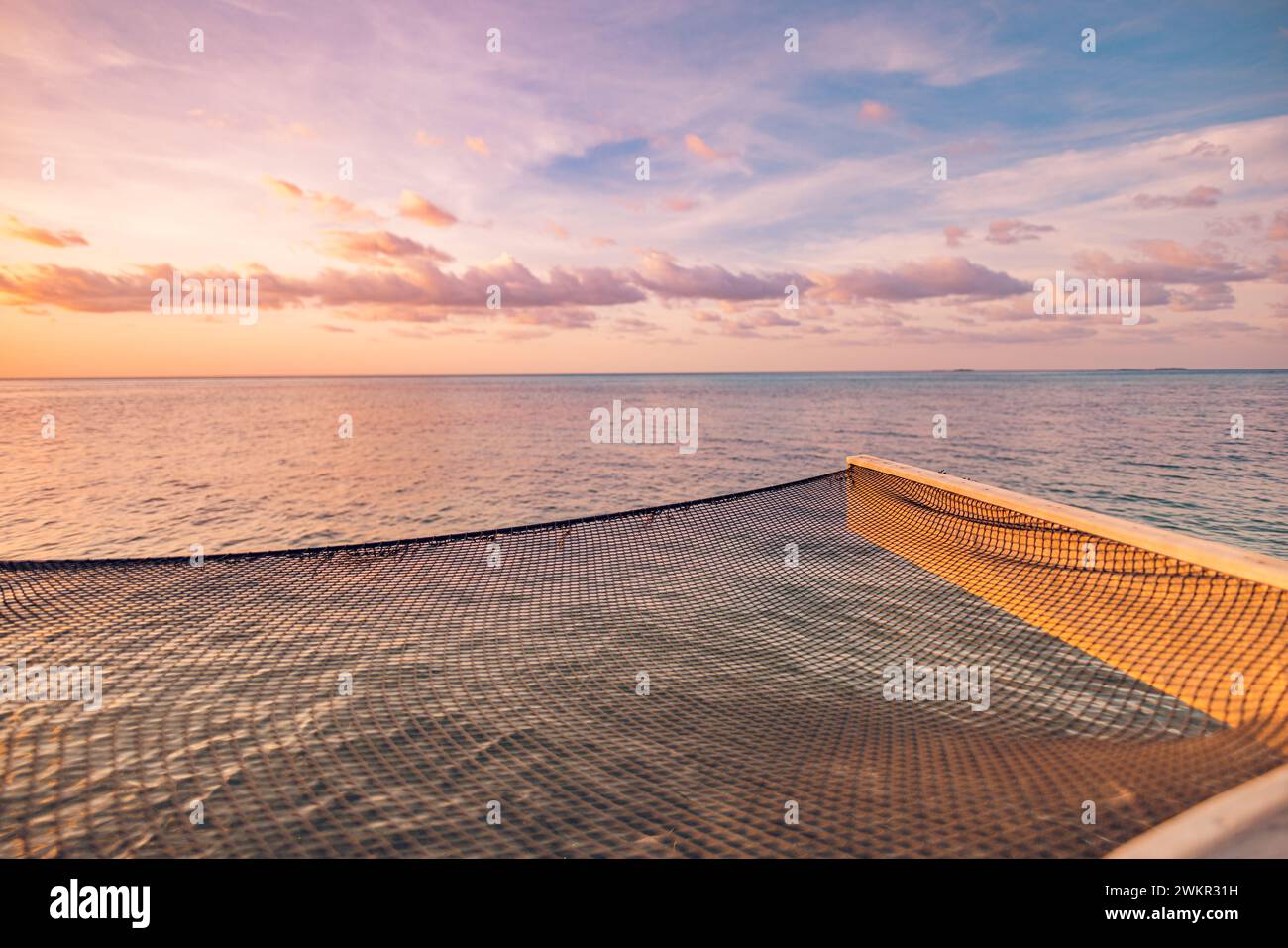 Over water hammock with dreamy sunset sea view, horizon. Inspire ...