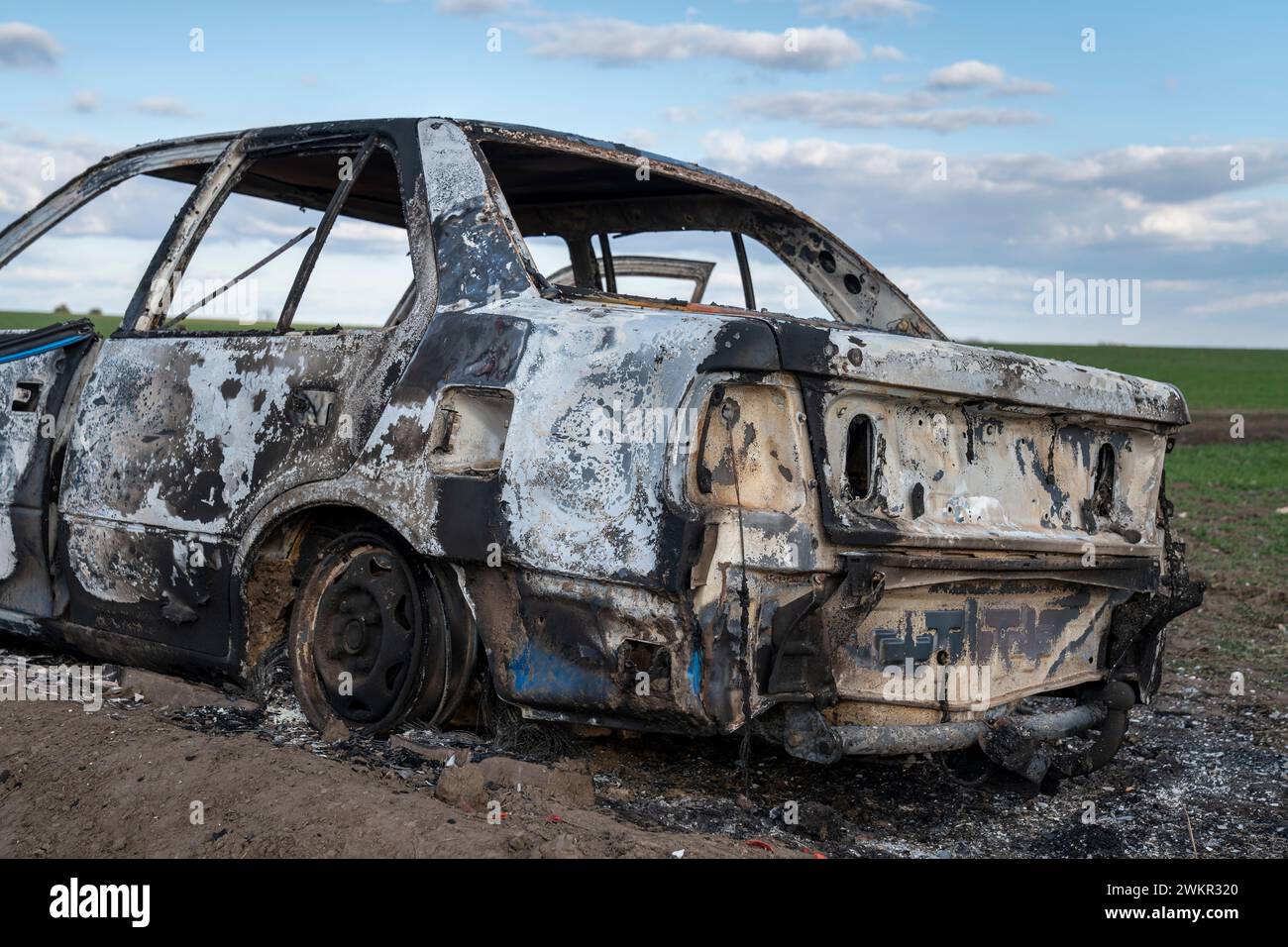 A burned out car. Burnt car in the field. Car fire, vehicle fire due to ...