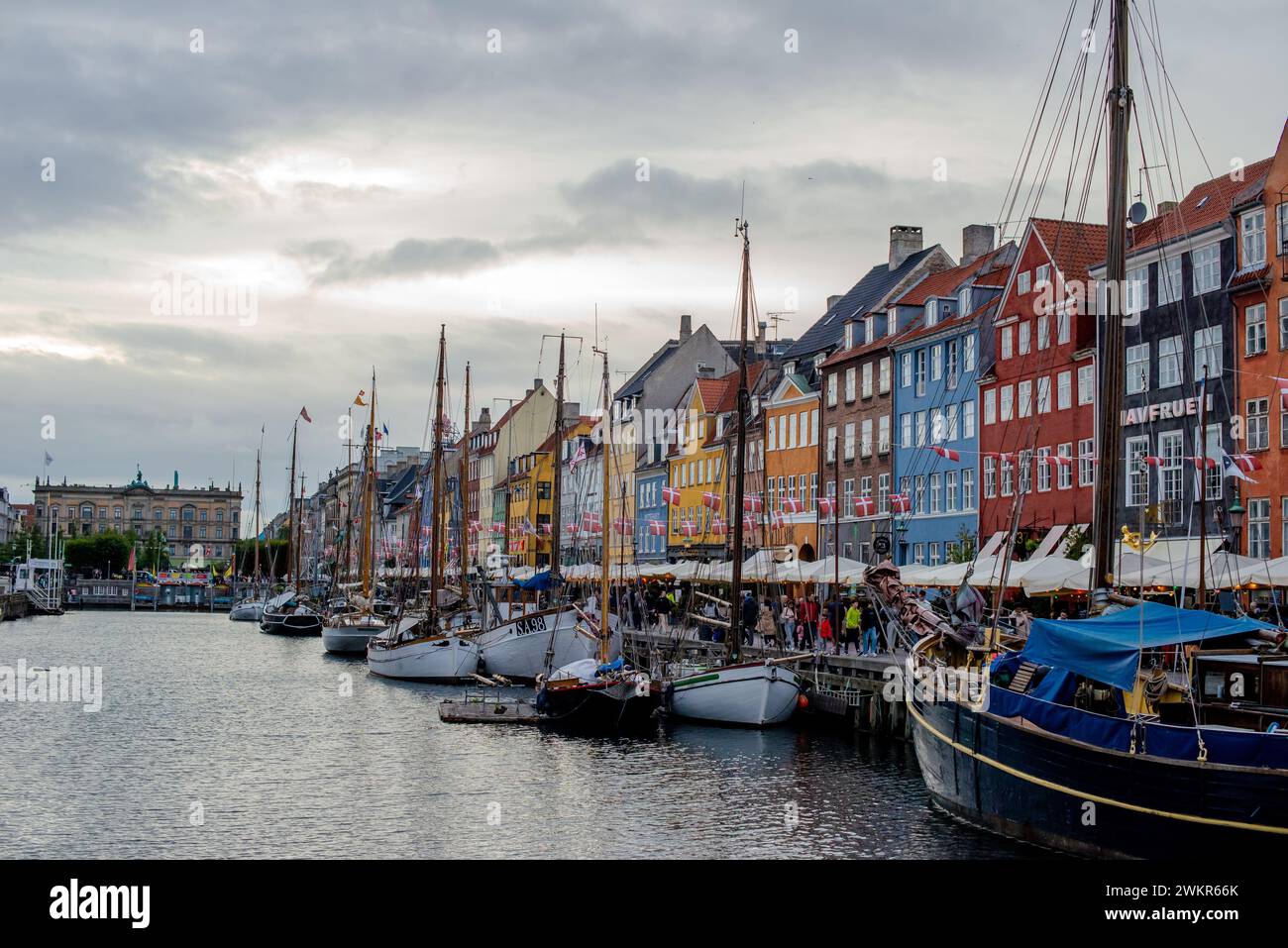A scenic river view of vibrant buildings and boats in Copenhagen ...