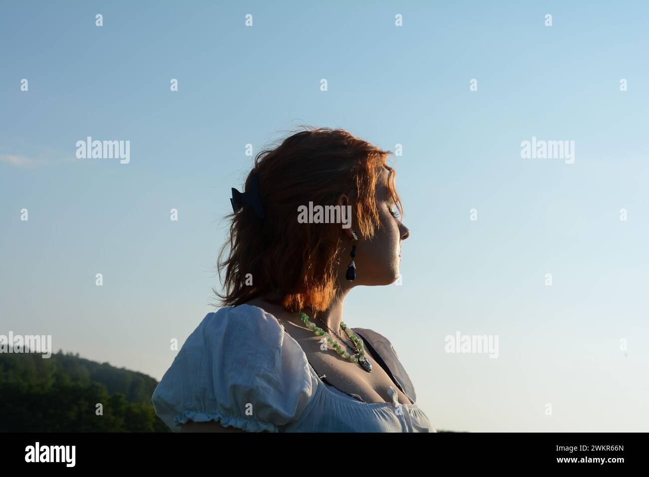 Profile of a pretty young woman, face to the sun, with sky Stock Photo ...