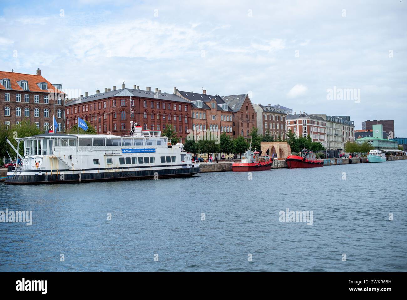 A scenic river view of vibrant buildings and boats in Copenhagen ...