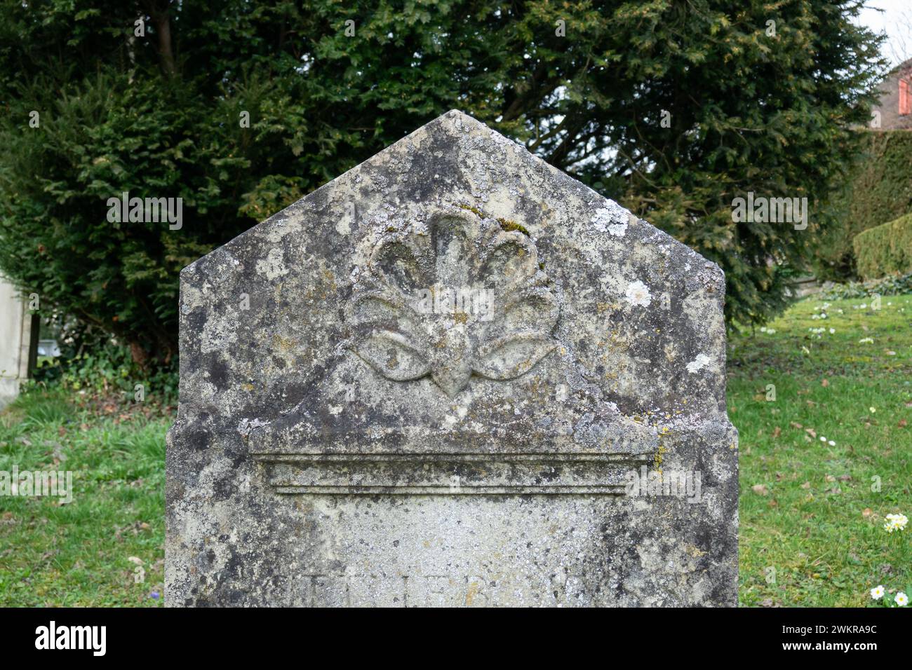 Old generic headstone or tombstone in a European church backyard. Close ...