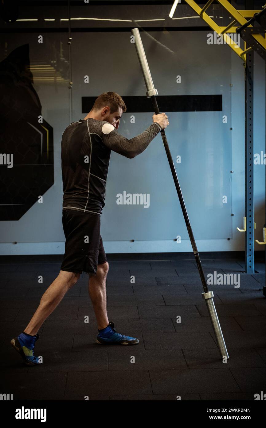 Boxer performing specialized barbell exercise for punch power at gym ...