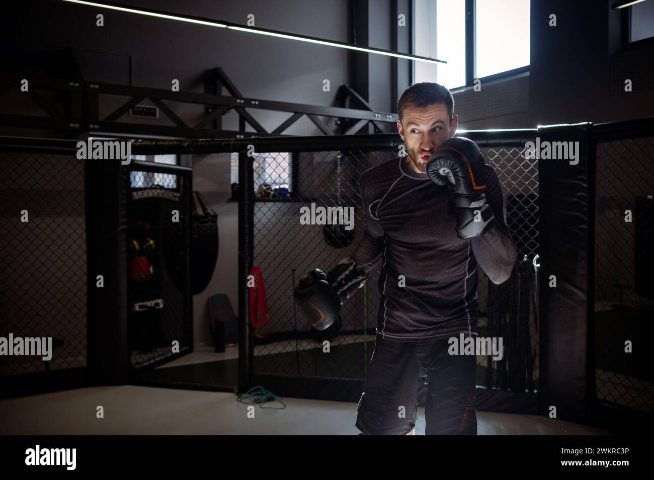 Fighter training punches during shadow fight on octagon in boxing gym ...