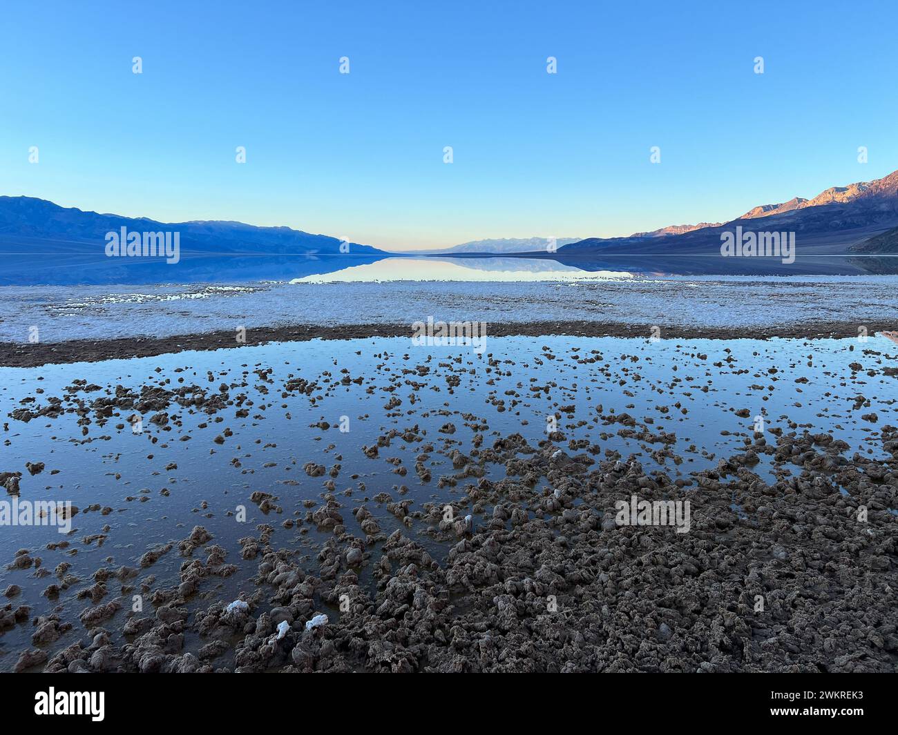 A scenic view of Lake Manly (Badwater Basin) in Death Valley at sunset ...
