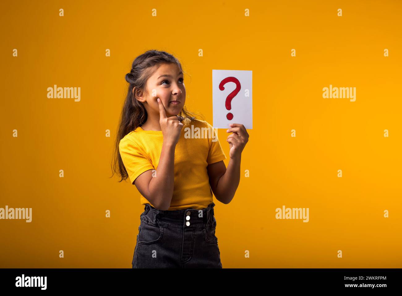 A portrait of thoughtful kid girl holding question mark card. Children ...