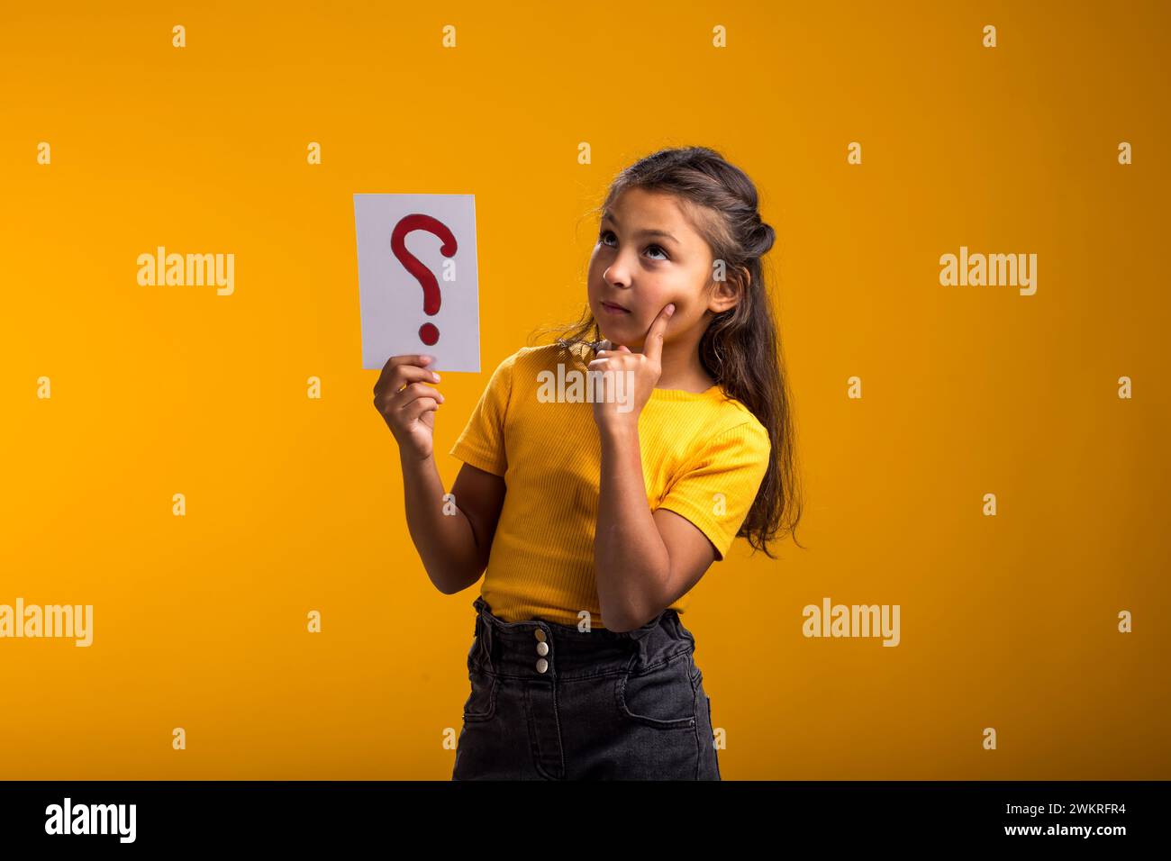 A portrait of thoughtful kid girl holding question mark card. Children ...