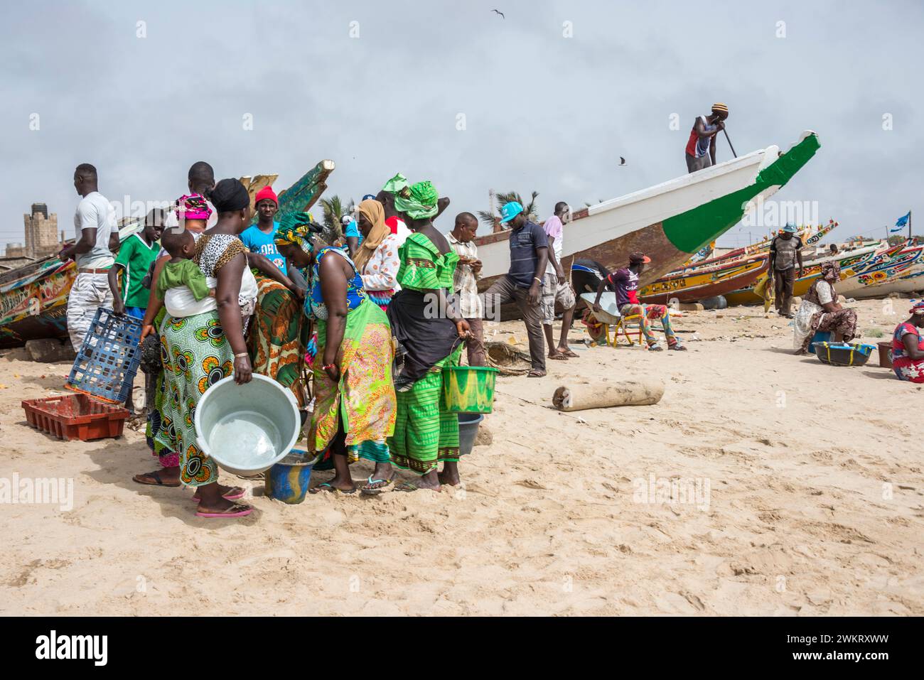 Group of women around fishing boats on a beach on the Gambian coast ...