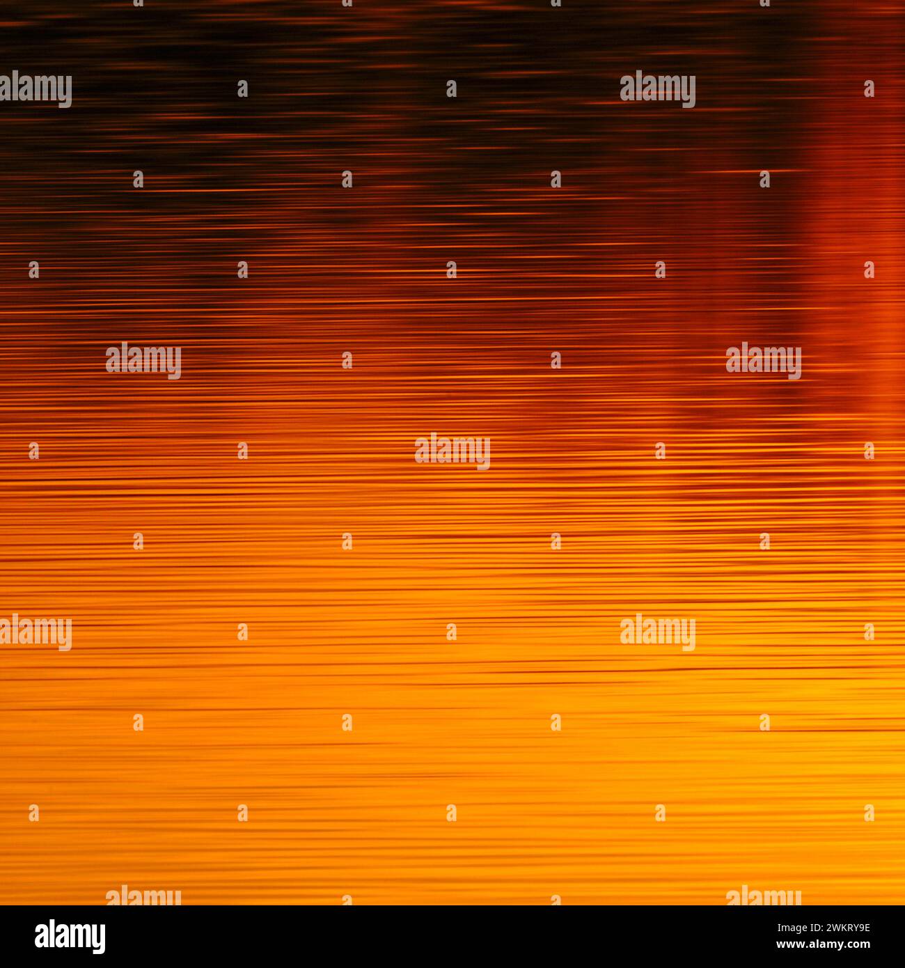 Sunset reflecting on calm water in nice warm orange red tones, full of ...