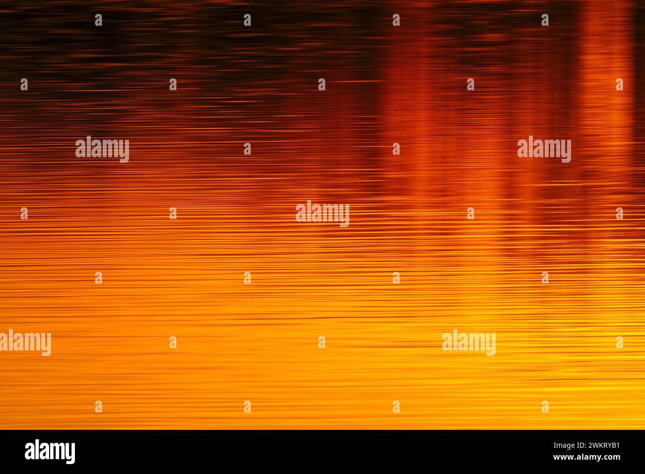 Sunset reflecting on calm water in nice warm orange red tones, full of ...