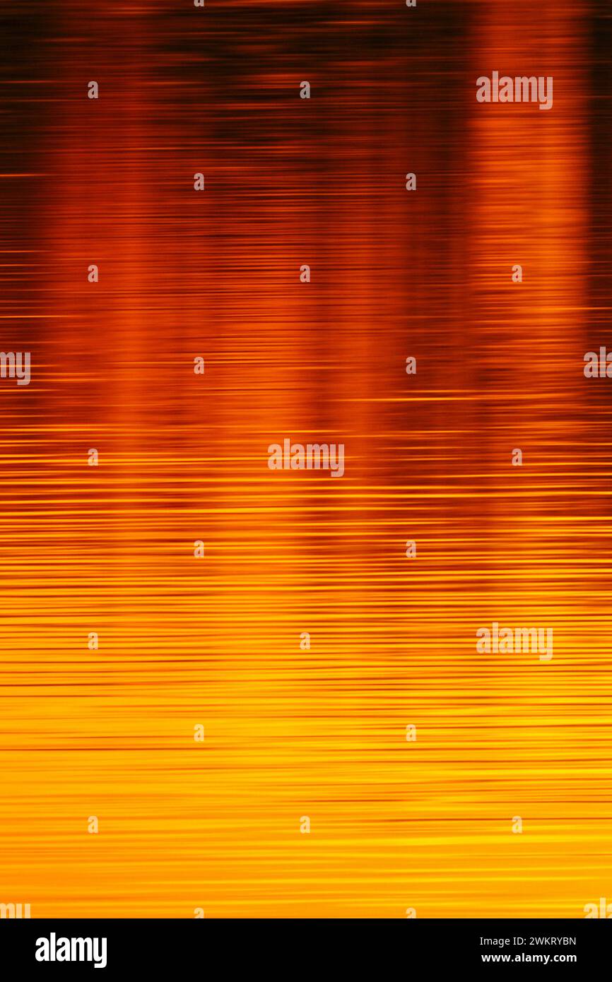 Sunset reflecting on calm water in nice warm orange red tones, full of ...