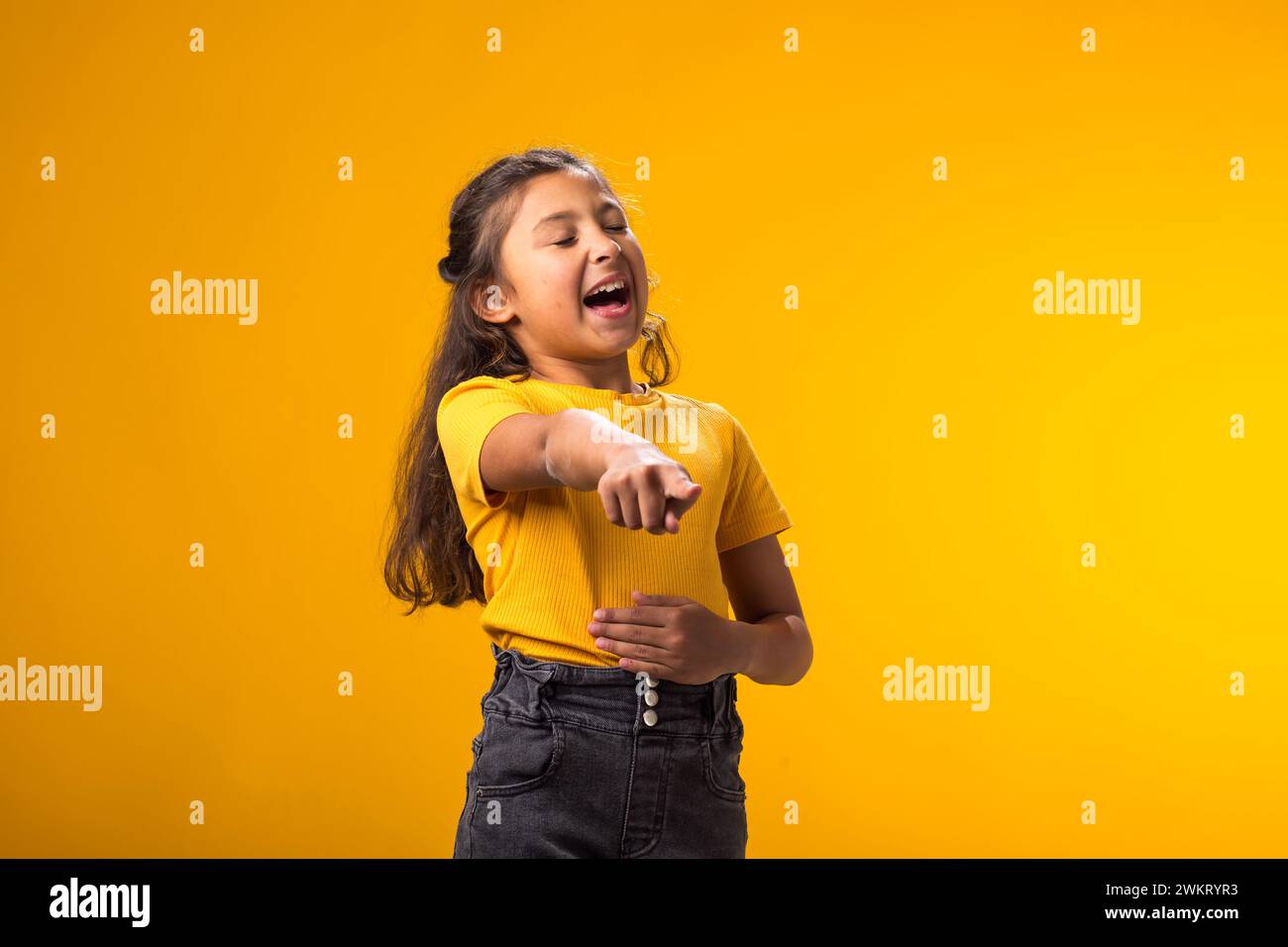 Portrait of kid girl mocking and teasing at someone showing finger at ...