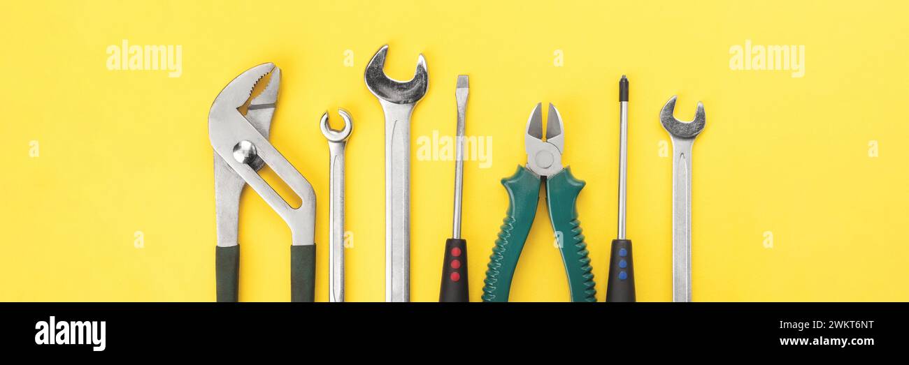 Work tools on bright yellow background banner. Panoramic web header ...