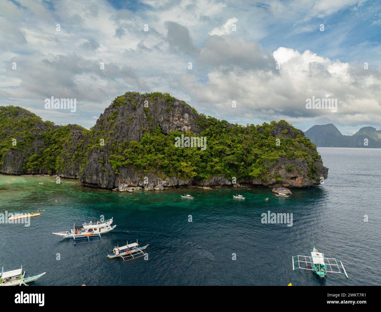 Tour boats and kayaks floating over the blue sea. Lagoons in Miniloc ...