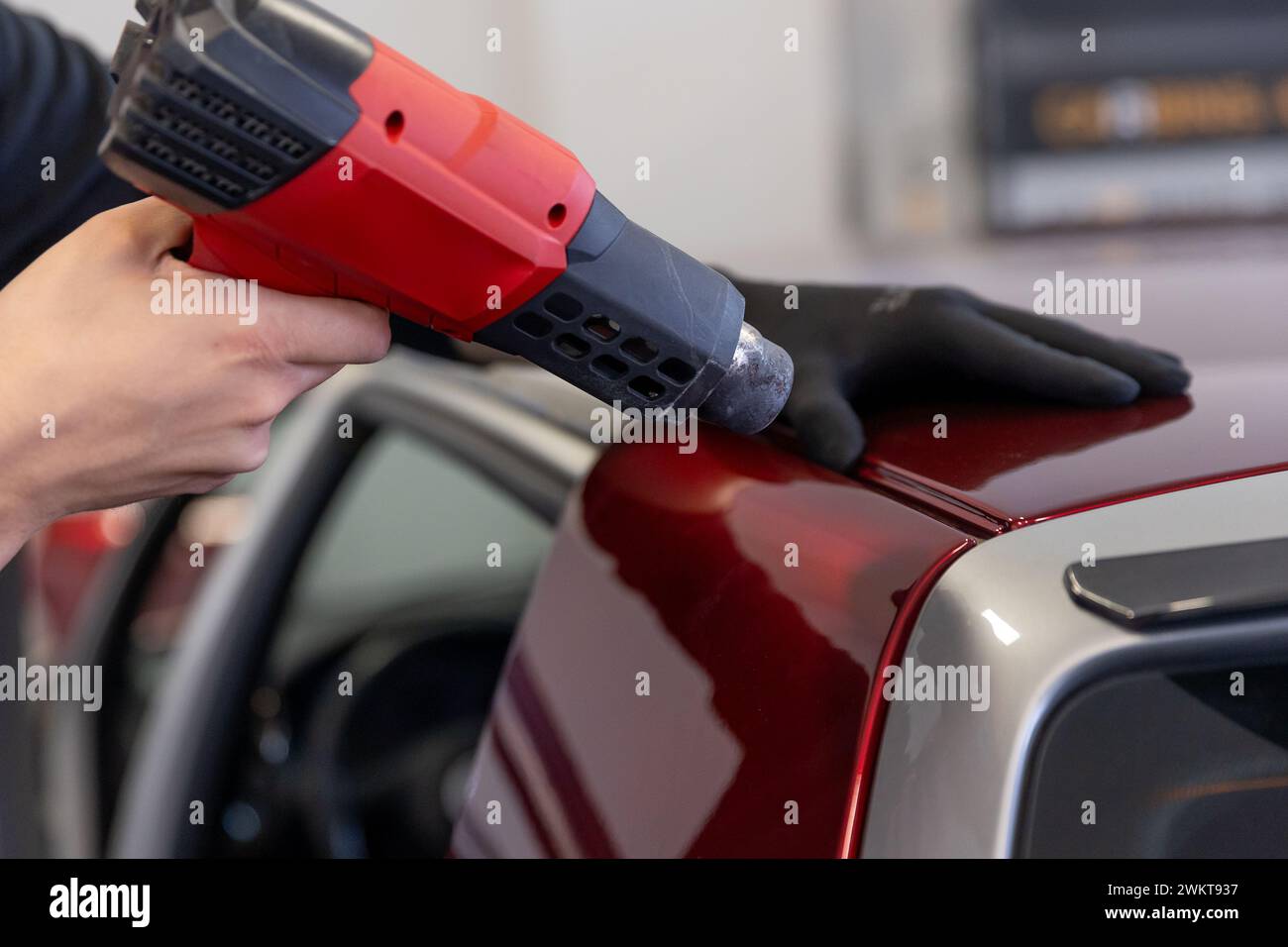 Wrapping a new foil to a car by heat gun, gluing a new foil, detailing ...