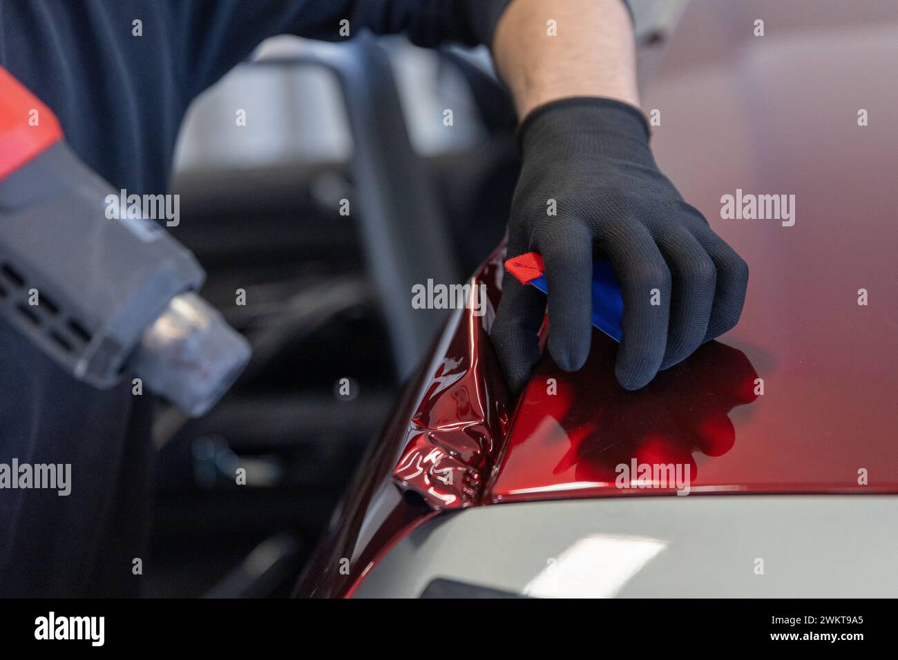 Wrapping a new foil to a car by heat gun, gluing a new foil, detailing ...