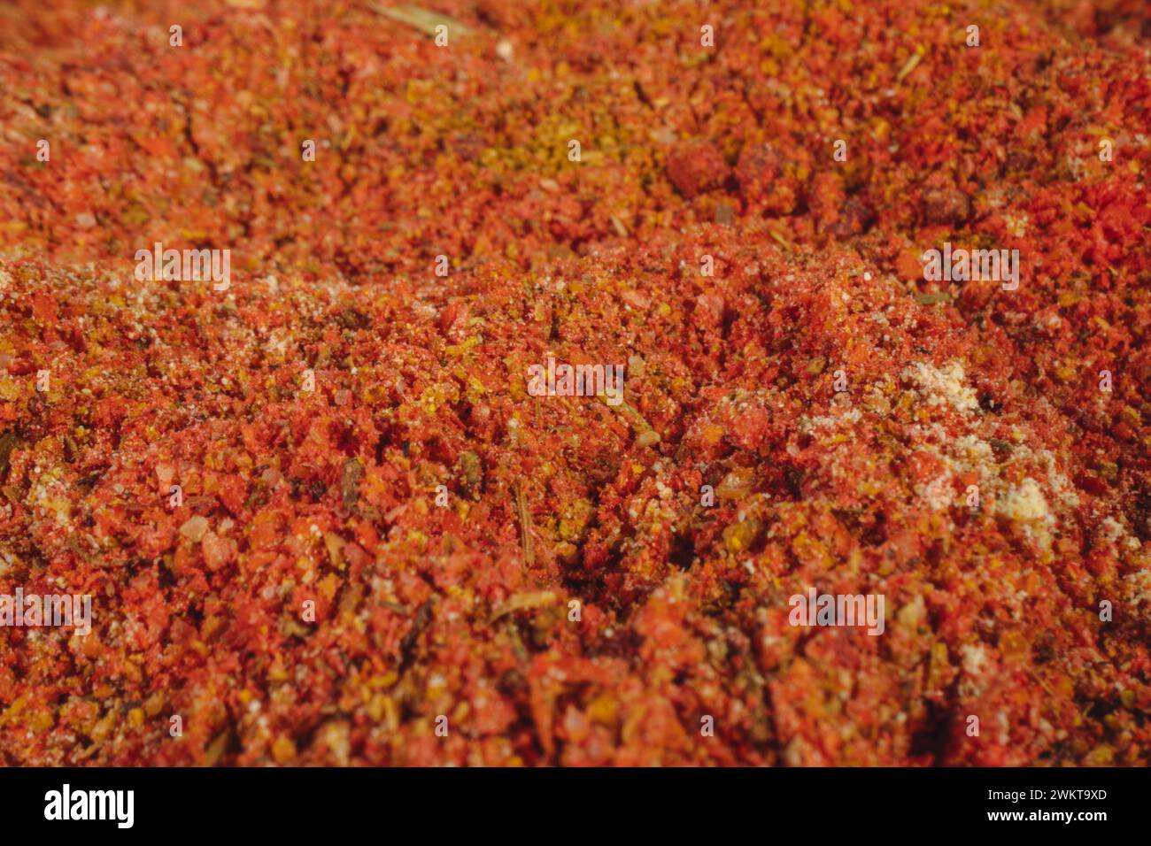 Assorted seasonings in a pile. Background of red paprika powder. Close ...