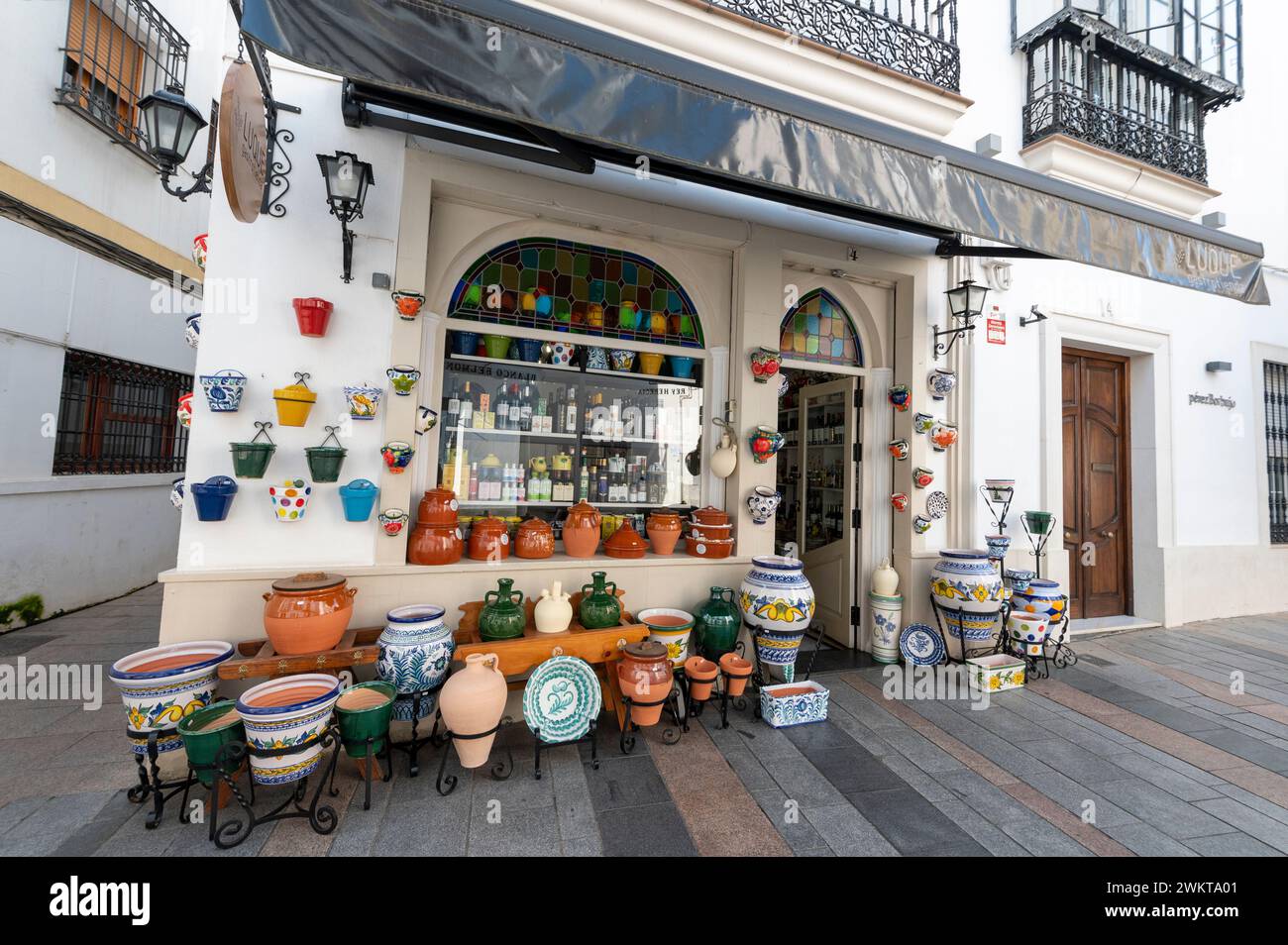 A florist with a display of flower pots on sale in a narrow side street ...