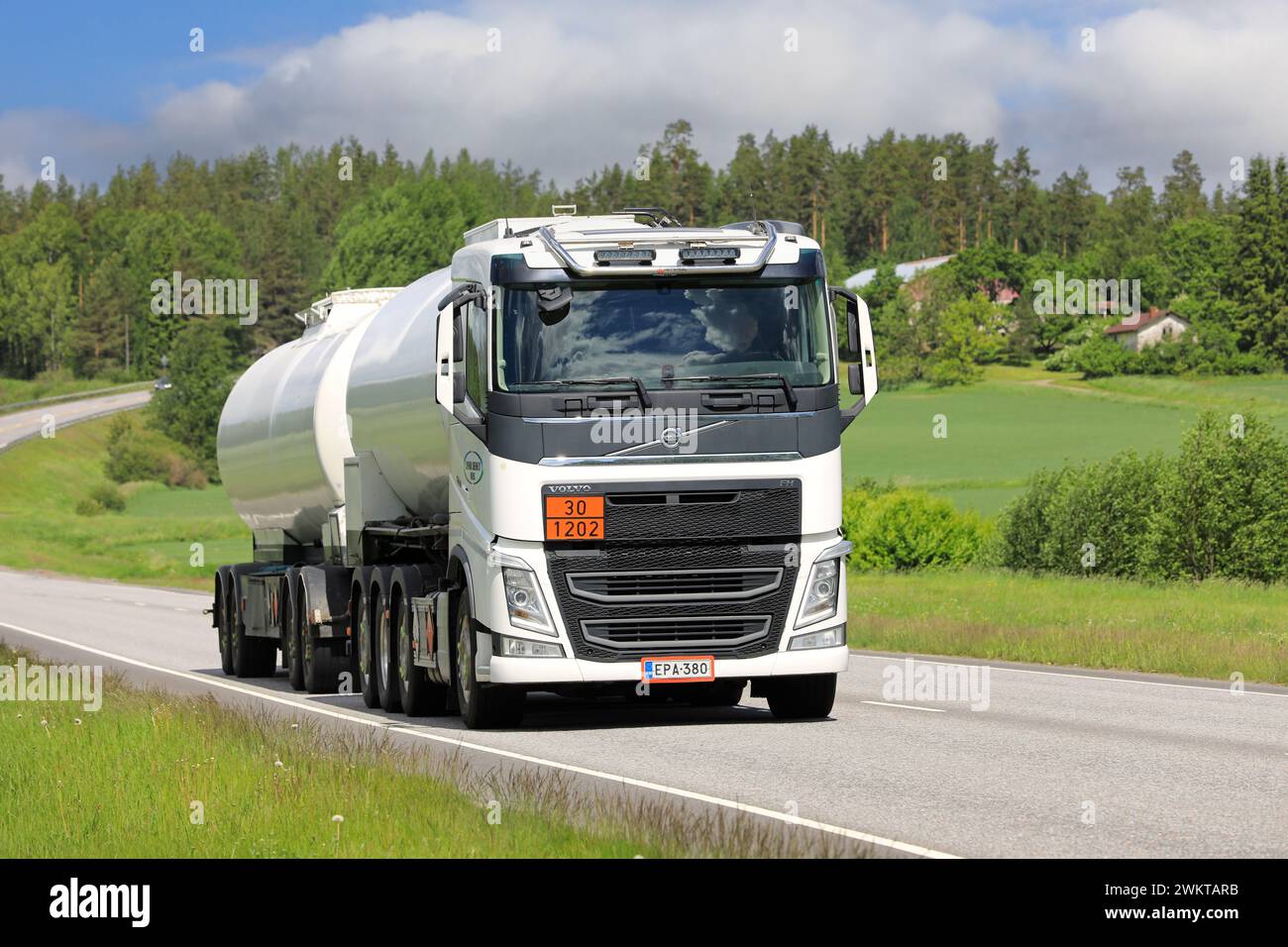 White Volvo FH tank truck transports diesel fuel, ADR code 33-1203, on rural highway on a day of ...