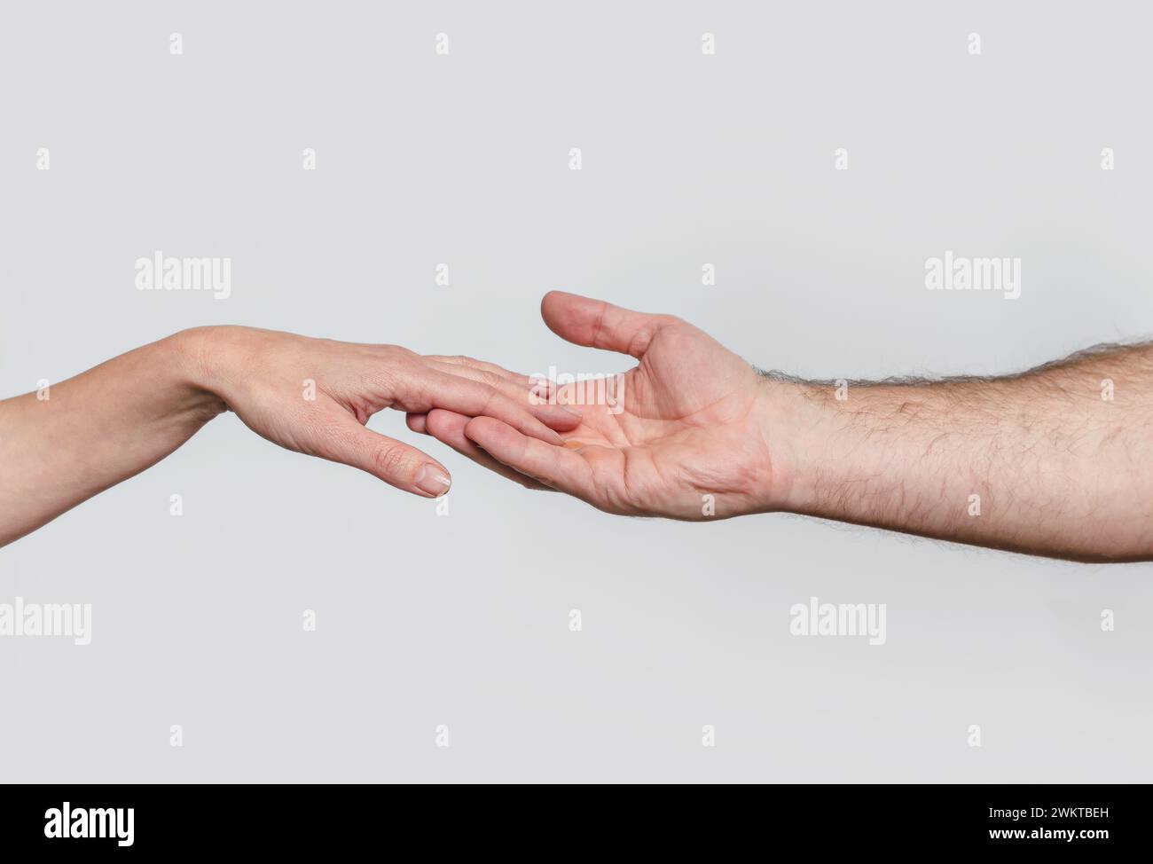 Man's hand carefully supports woman's hand. Gray background. Harmonious ...