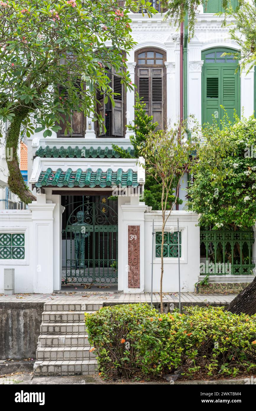 The trees by the building entrance with green shutters Stock Photo - Alamy