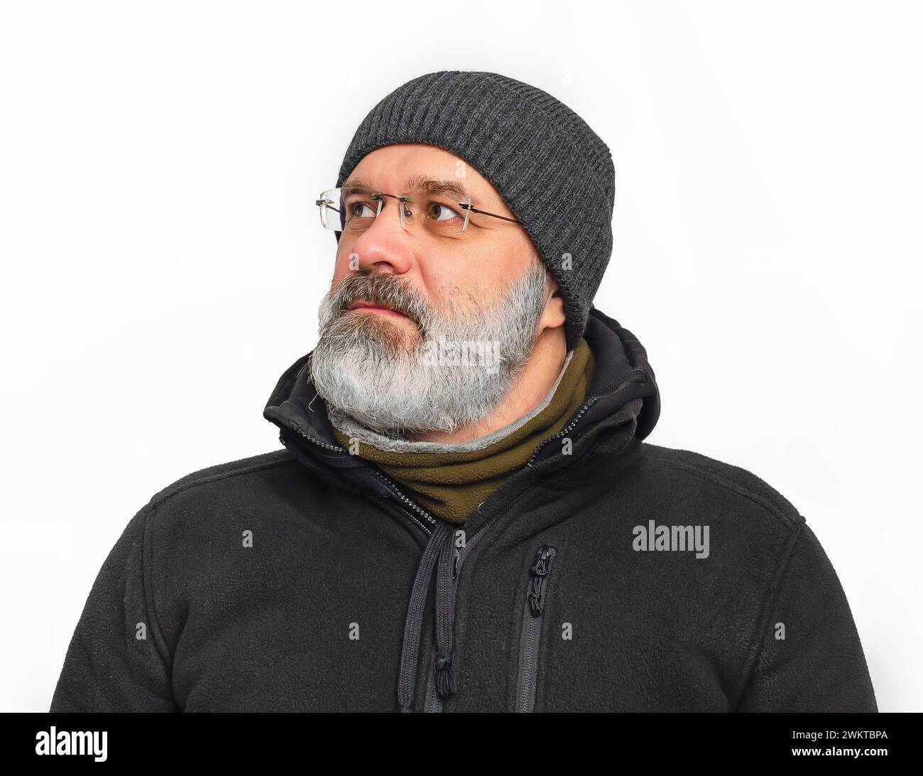 Stylish serious man with gray beard and mustache in winter hat. He looks away. White background ...