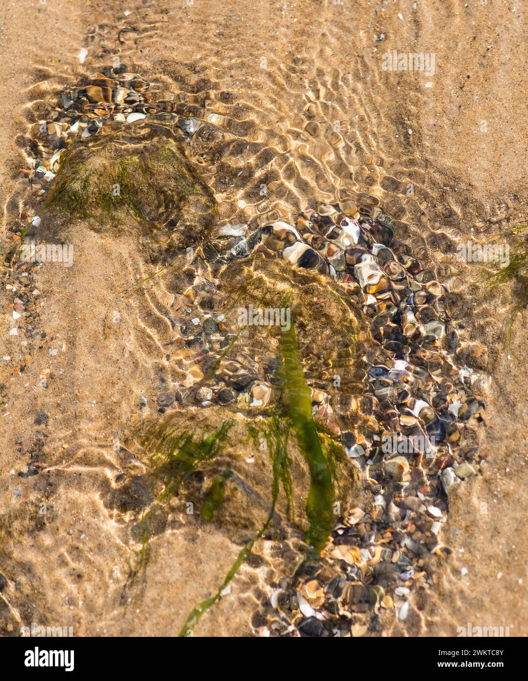 Abstract effect an ebbing low tide has, causing colourful patterns as ...