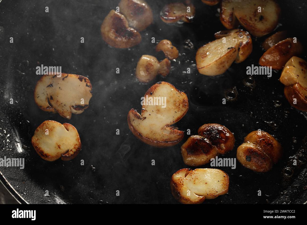 Frying forest mushrooms boletus served in iron cast pan. Vegetarian ...