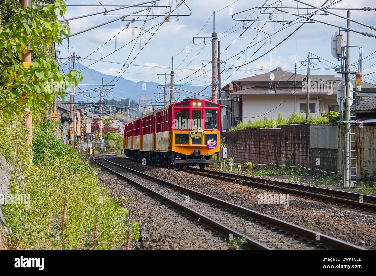 Romantic train near Kyoto in Japan, in yellow and red colors, rolling ...