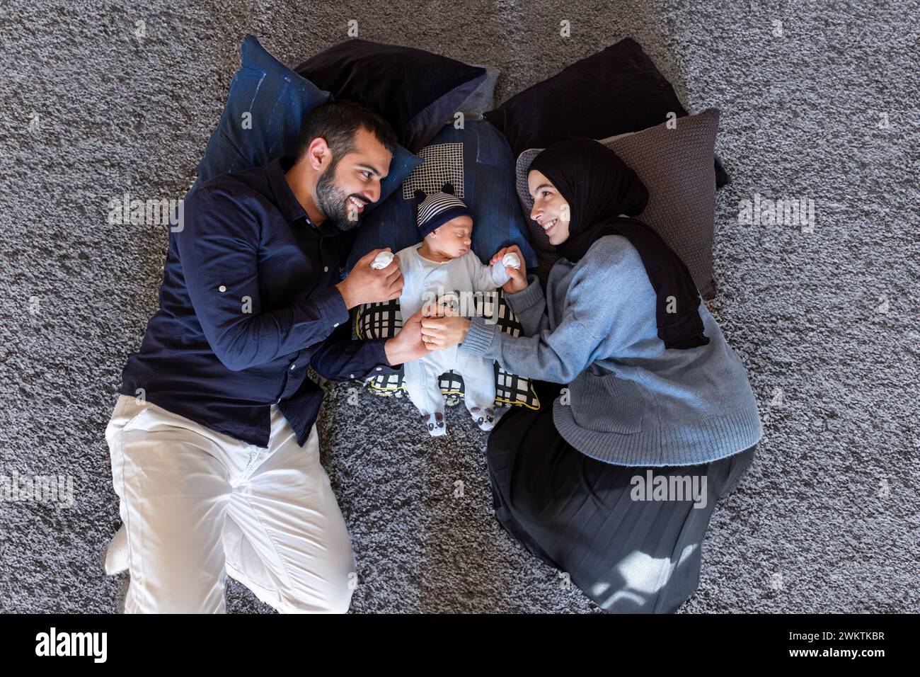 Arabic Muslim parents share a tender moment with their newborn daughter ...