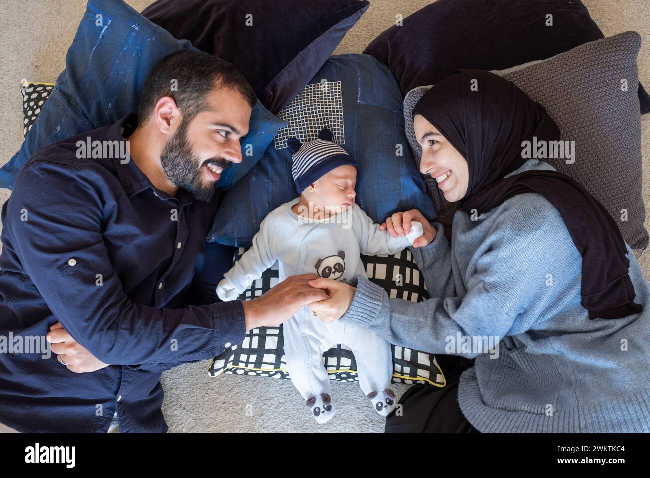 Arabic Muslim parents share a tender moment with their newborn daughter ...