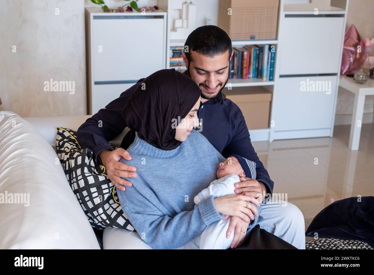Arabic Muslim parents share a tender moment with their newborn daughter ...