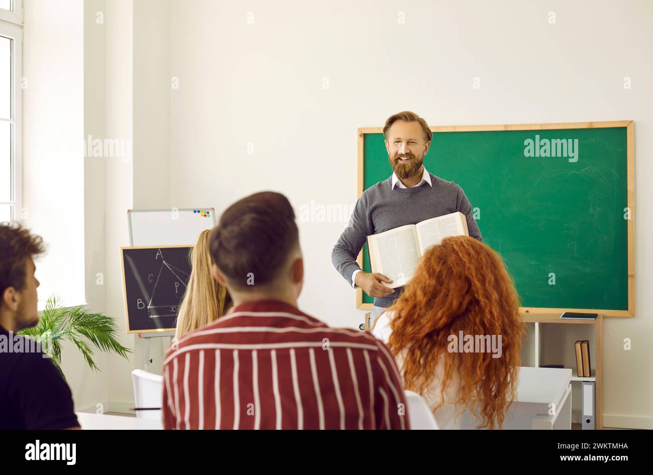 Group of outwardly attractive students listen attentively to their ...
