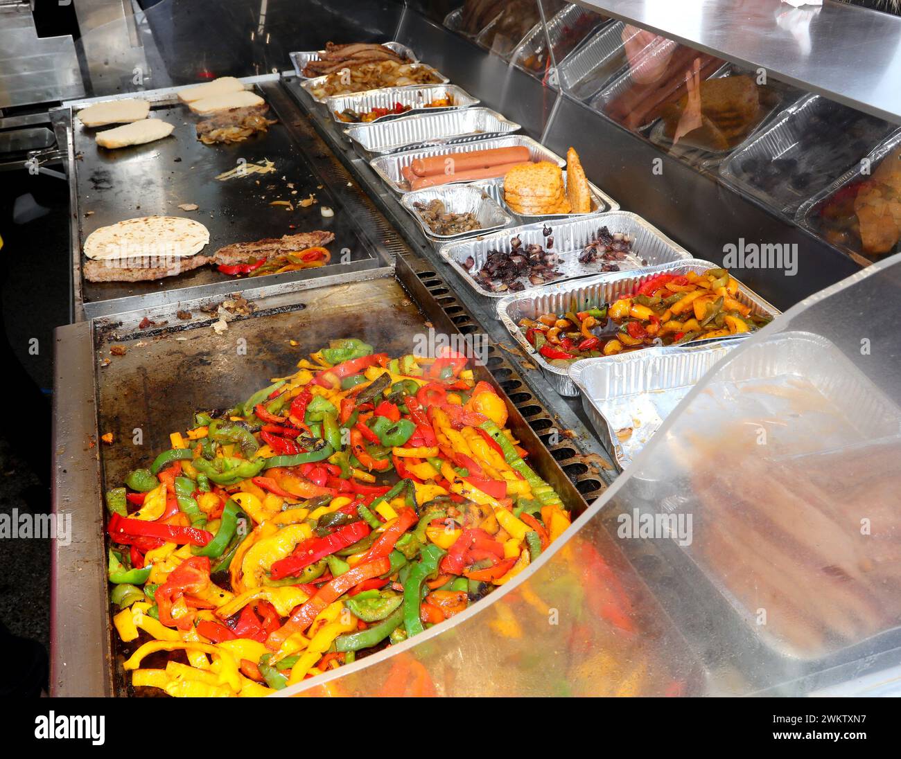 peppers sizzle on the hot griddle of a bustling street food truck ...