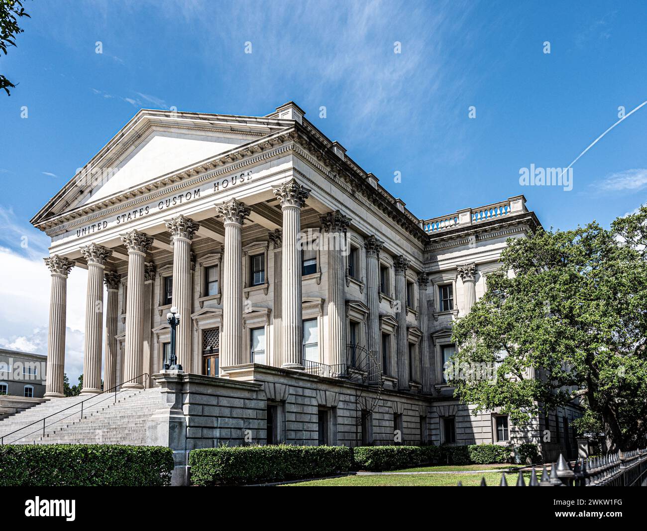 A stone building with pillars, columns, grass, and stairs Stock Photo ...