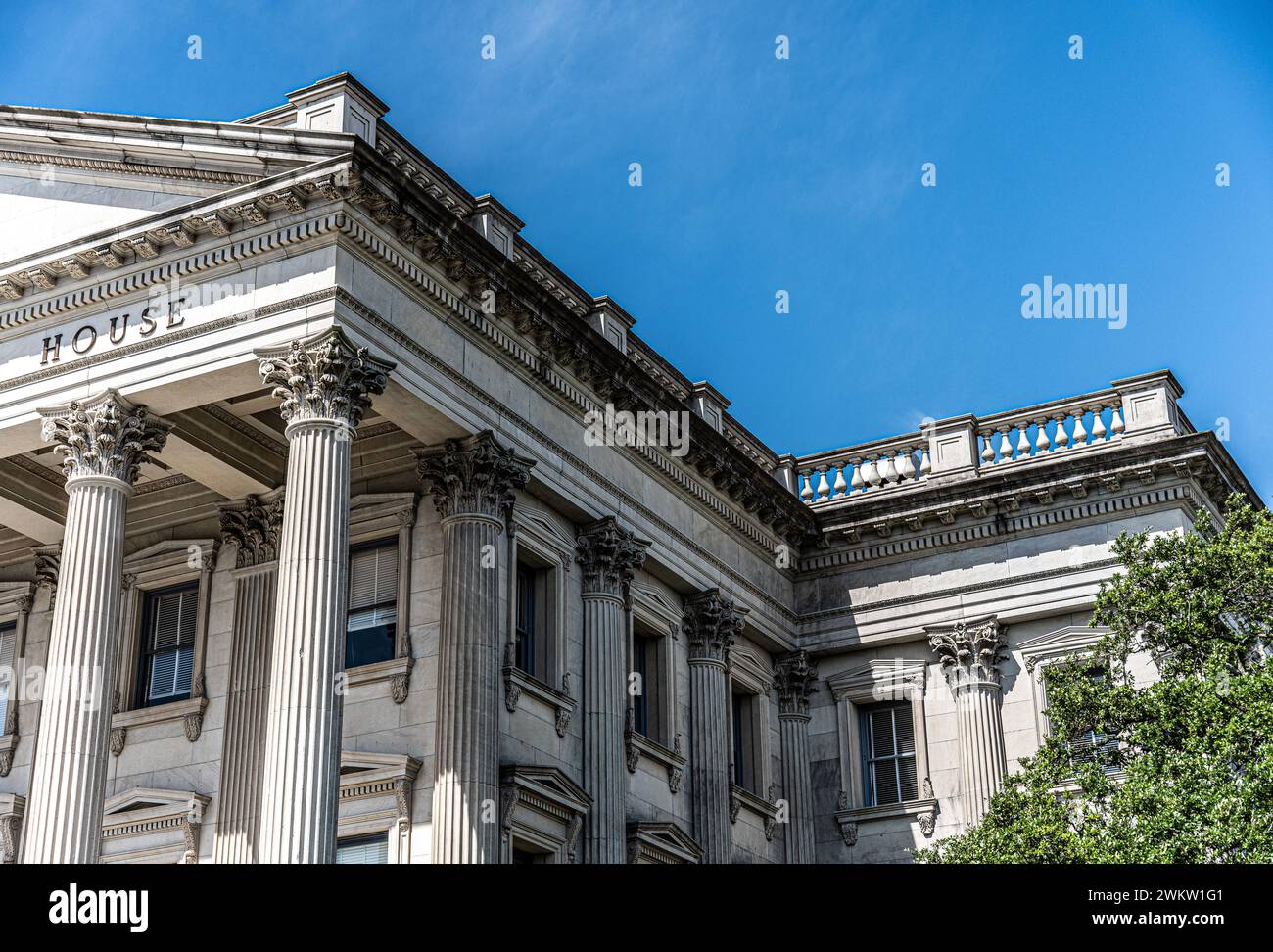 A grey stone building with a white clock tower on the side Stock Photo ...