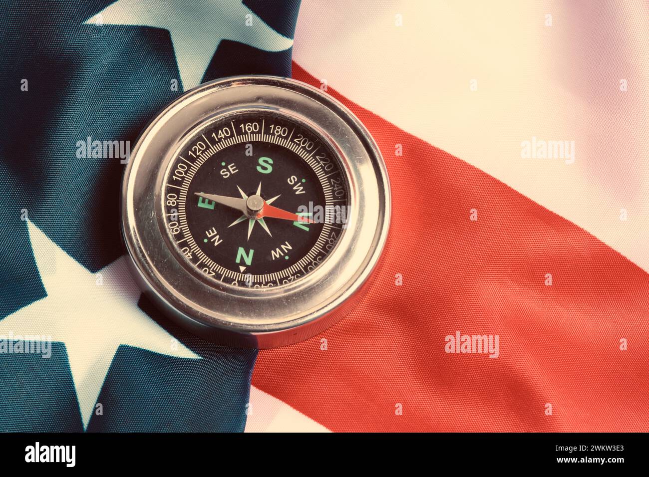 Compass pointing west and star spangled flag United States America ...