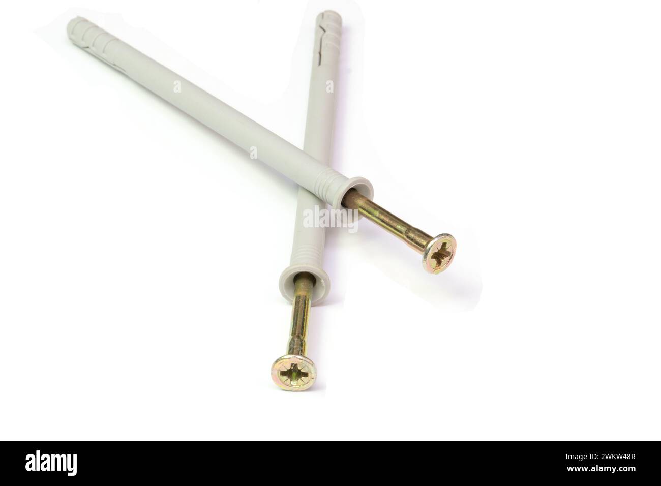 Gold torx screw and plastic dowel isolated on white. Yellow zinc screw ...