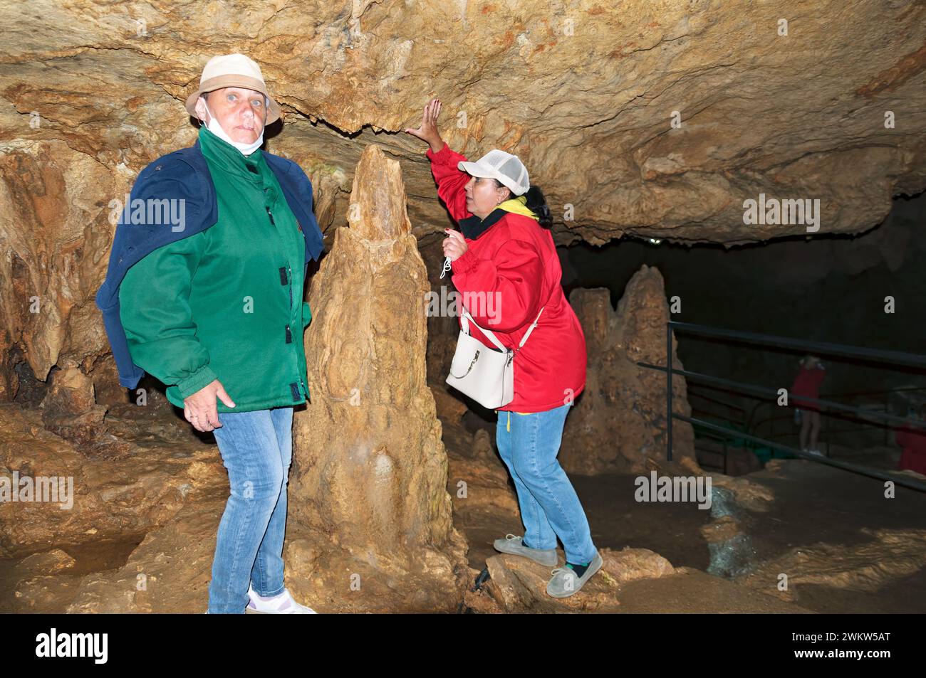 Two women, members of the tourist group, pose against the backdrop of ...