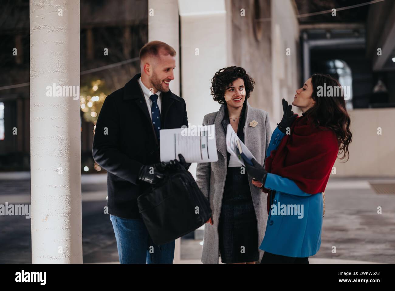 Three business colleagues engaged in discussion over paperwork ...