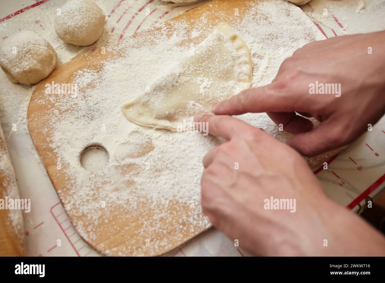 We roll the dough so that the filling is inside the cheburek. We pinch ...