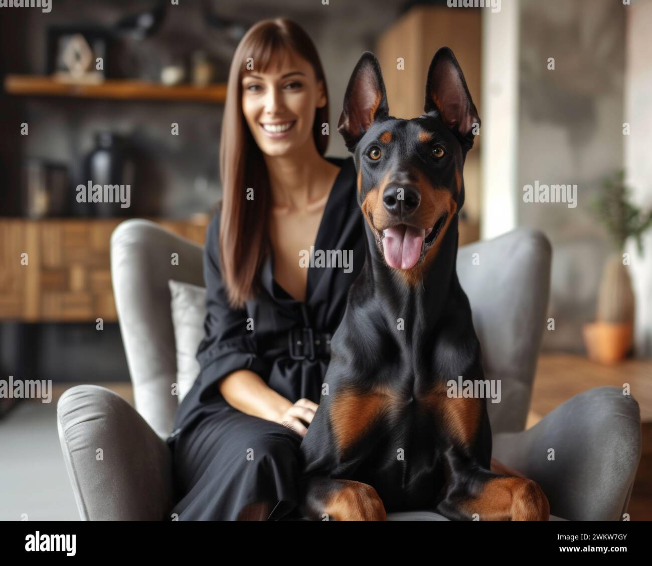 A woman seated in a chair with a dog beside her Stock Photo - Alamy