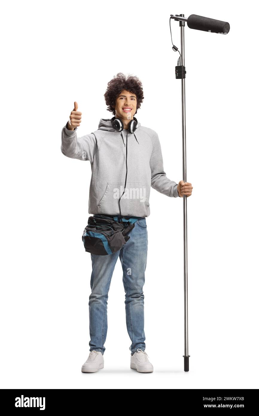 Boom operator with headphones holding a microphone and gesturing thumbs ...